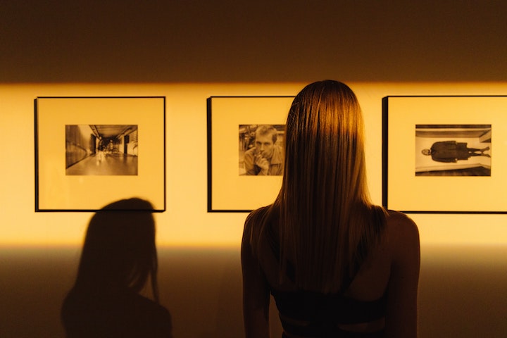 A beautiful woman with long hair in an art gallery is looking at ...